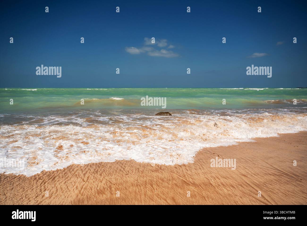 Green sea water, wave and foam, corrugated sand on beach, dark sky ...