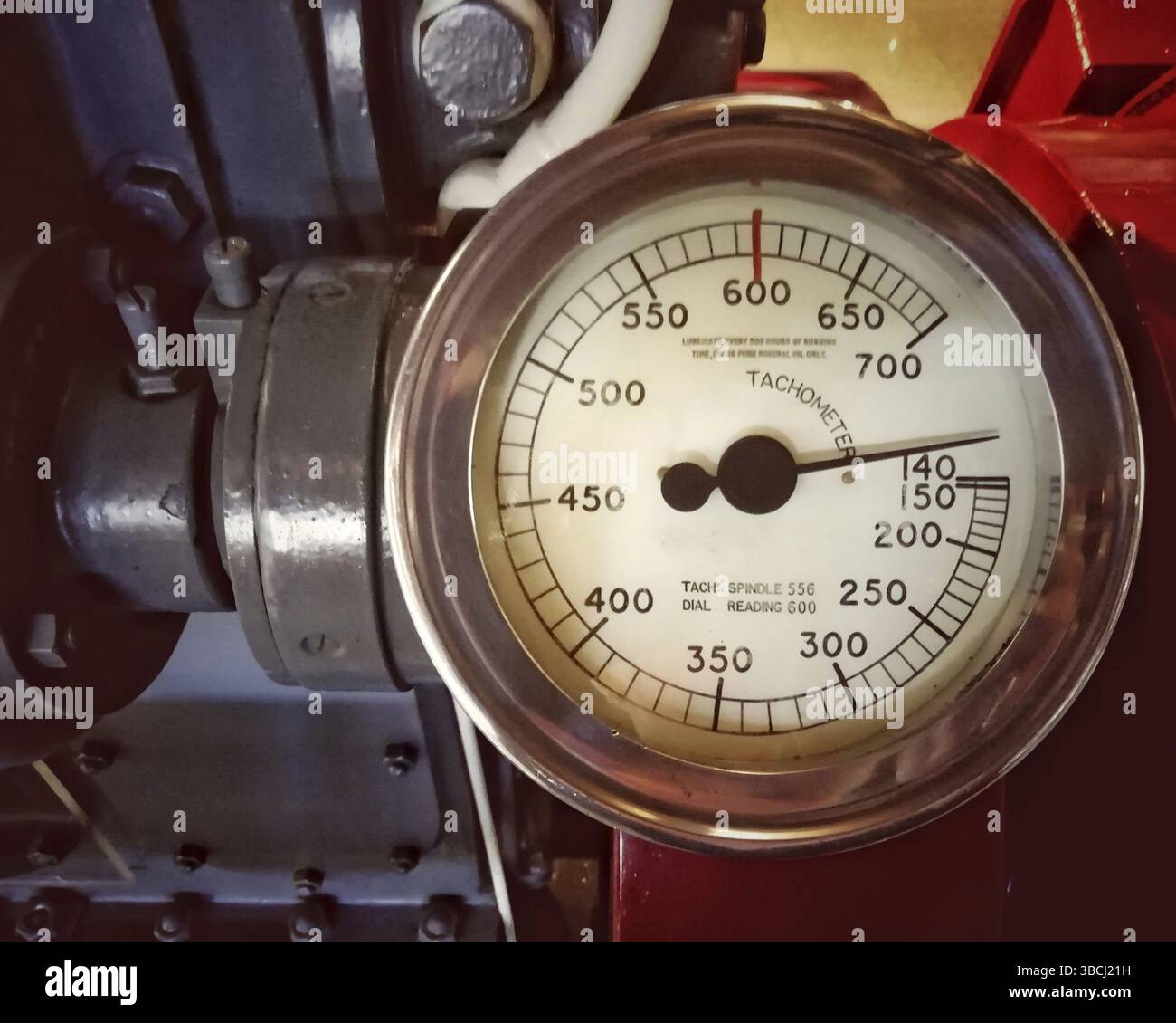 A large old metal tachometer with a round gauge with the dial marked in ...