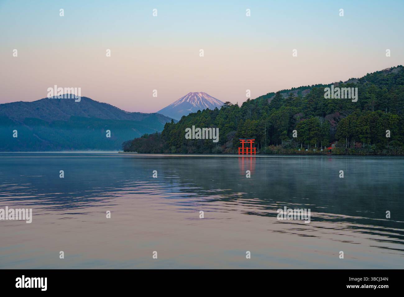Scenic view of Mount Fuji behind lush forest and iconic red torii gate ...