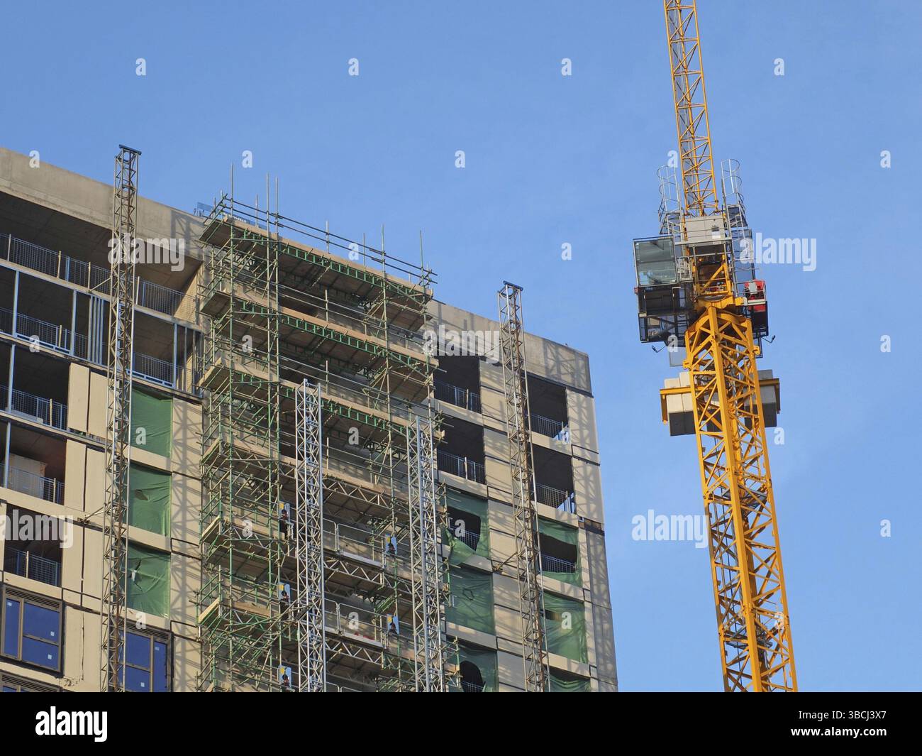 A large modern building under construction covered in scaffolding with ...
