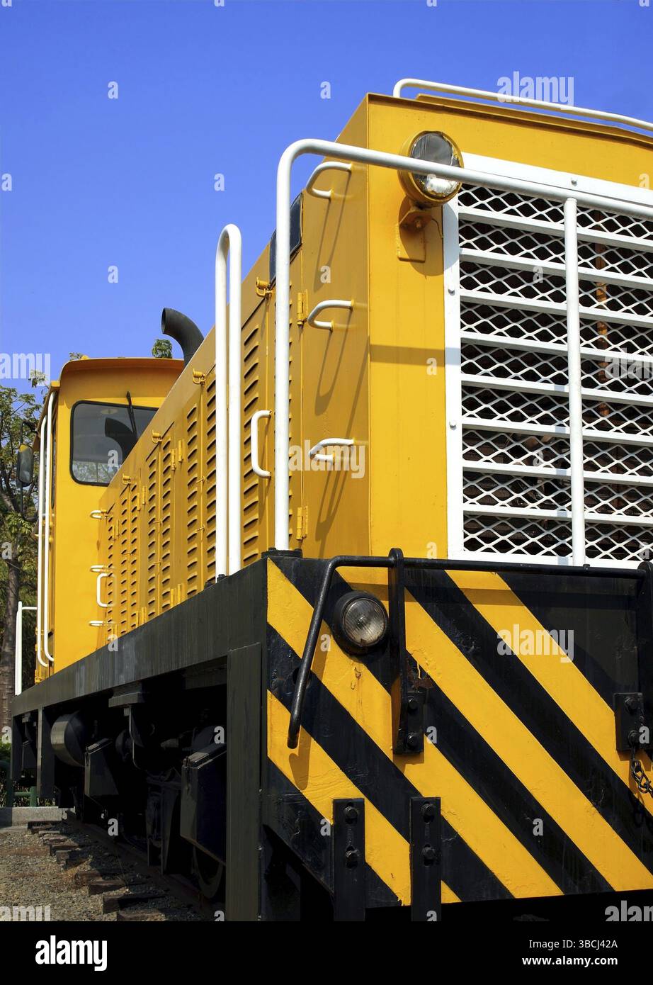 A bright yellow vintage diesel engine designed for narrow railway gauge ...