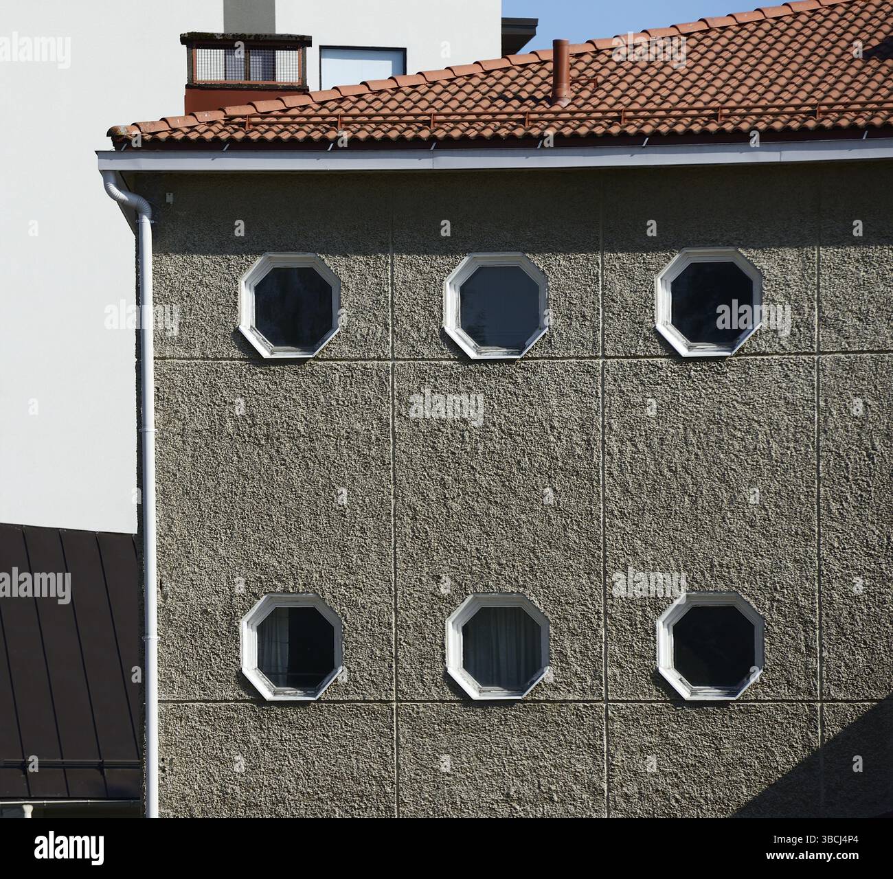 House facade with octagonal windows and roof with tiles Stock Photo - Alamy