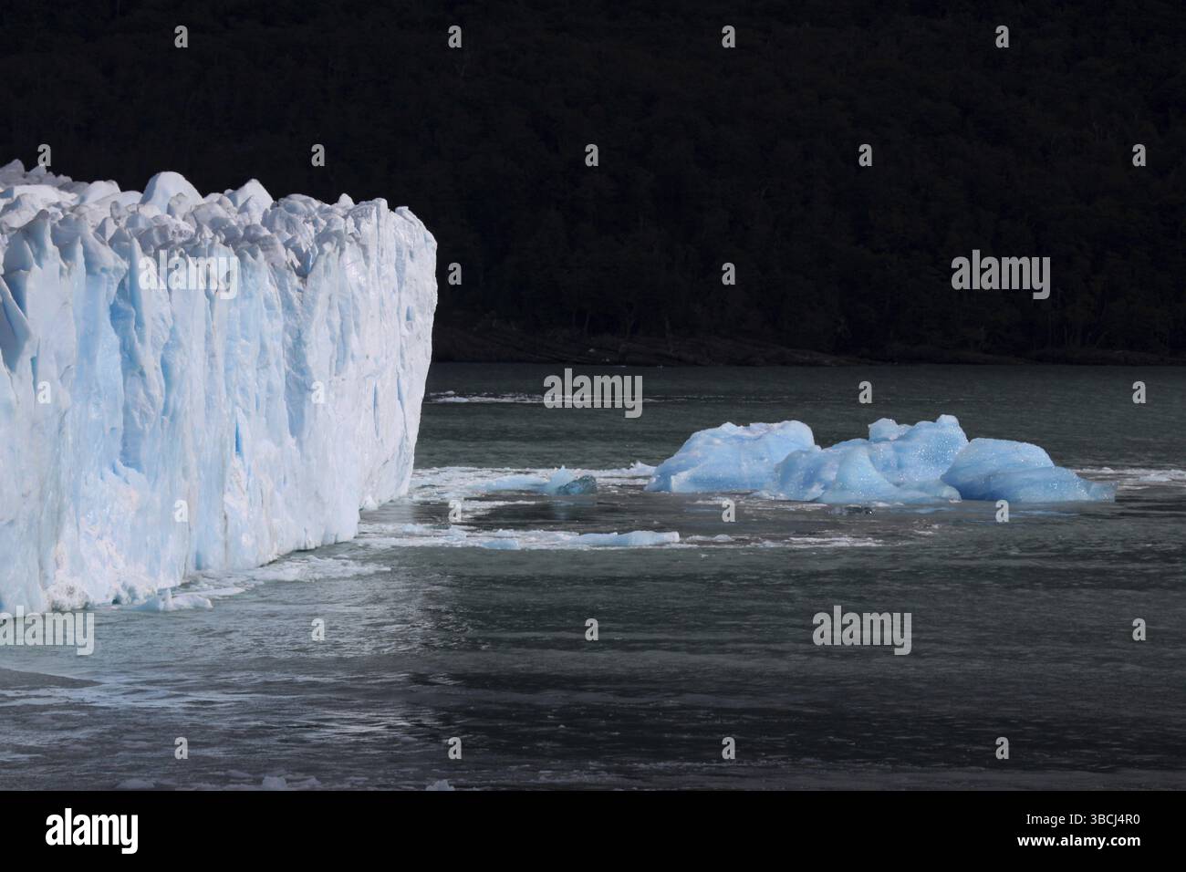 Broken chunk of ice floats in lake next to glacier Stock Photo - Alamy