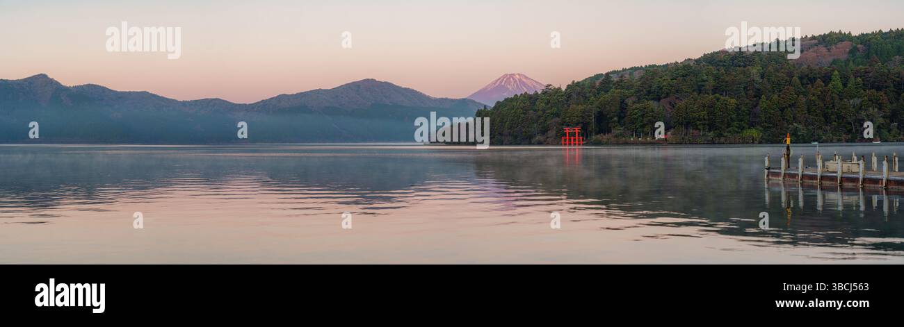 Scenic view of Mount Fuji behind lush forest and iconic red torii gate ...