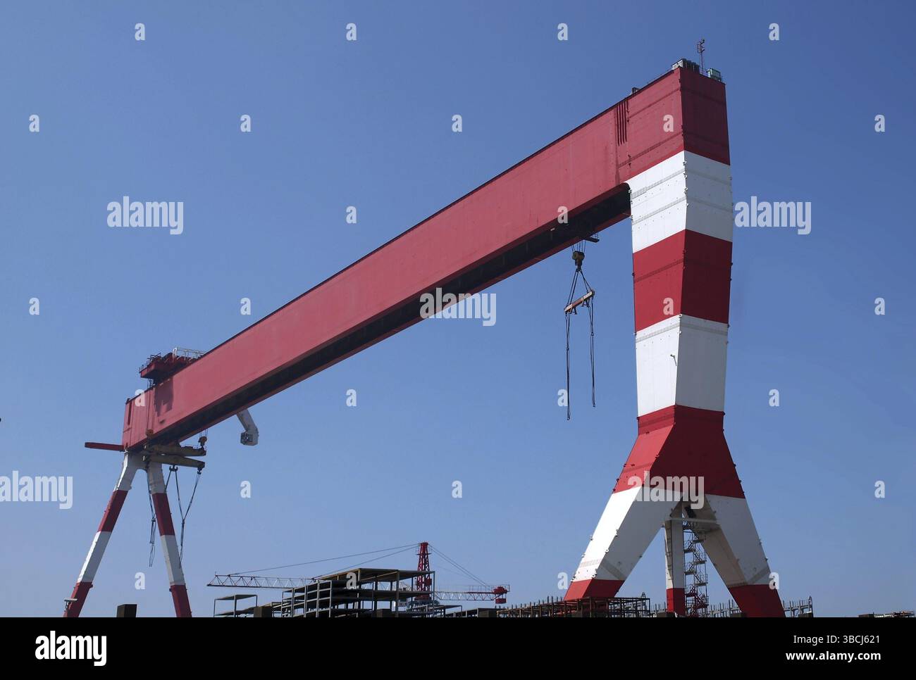 A large red and white gantry crane used for shipbuilding Stock Photo ...