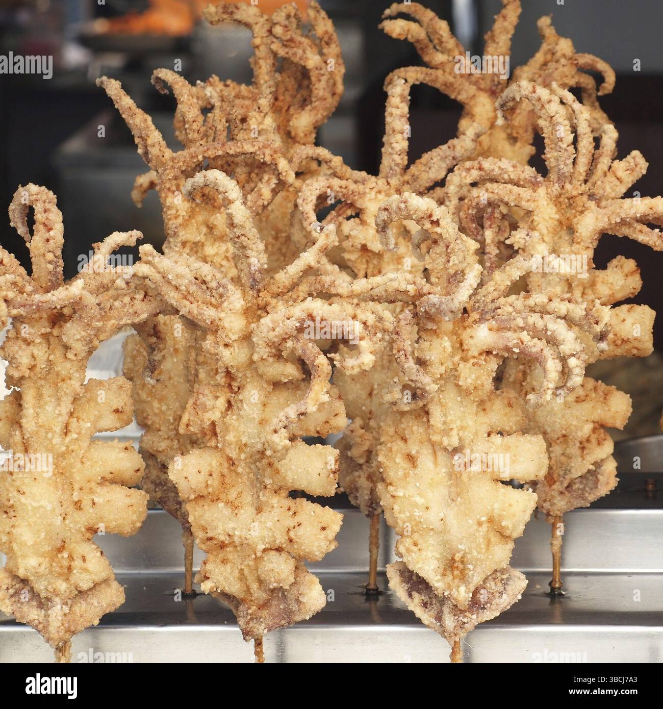 Deep fried octopus on skewers for sale at an outdoor stall Stock Photo ...