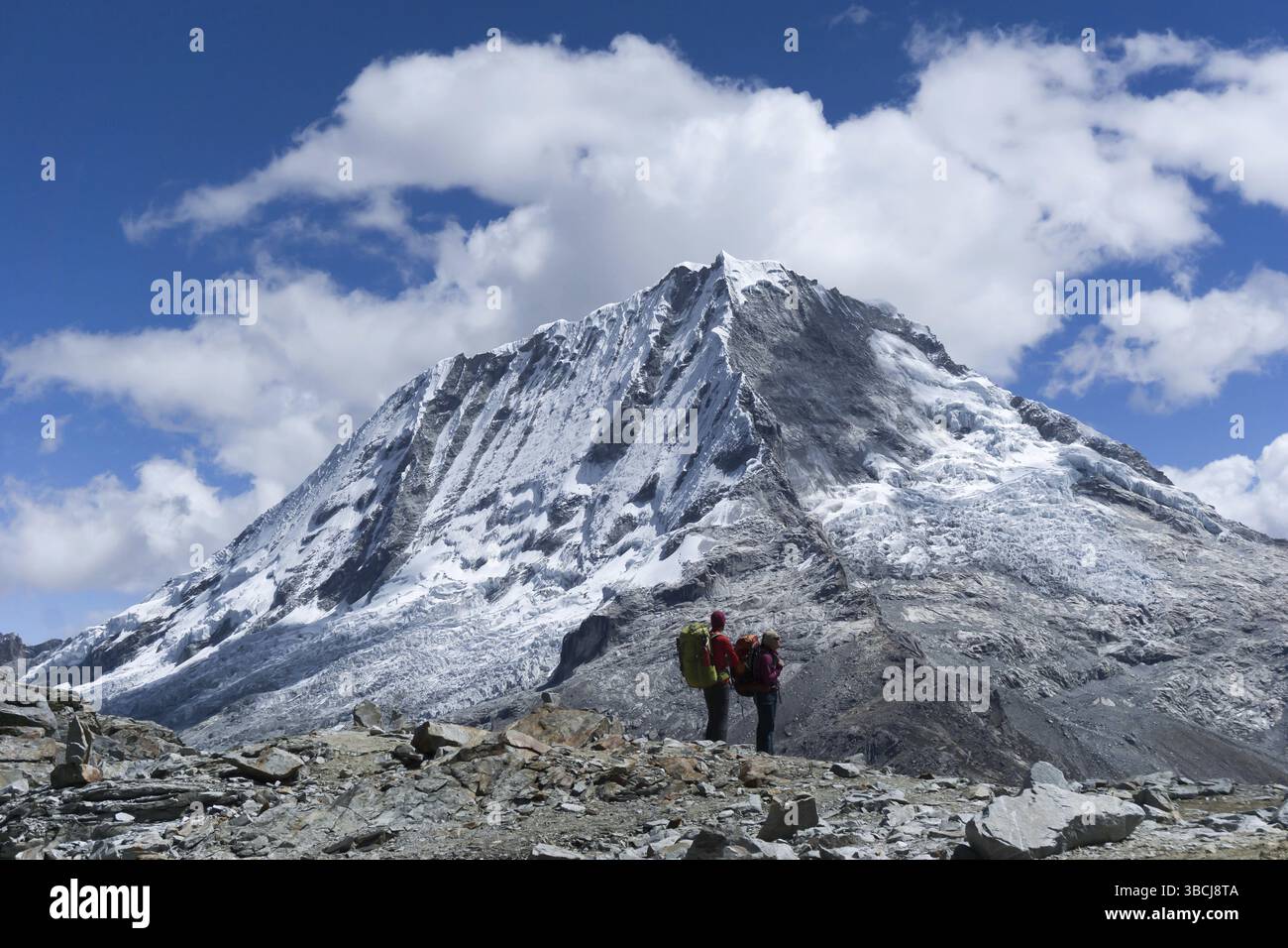man and woman backpacker couple admire the incredible view of the Andes ...