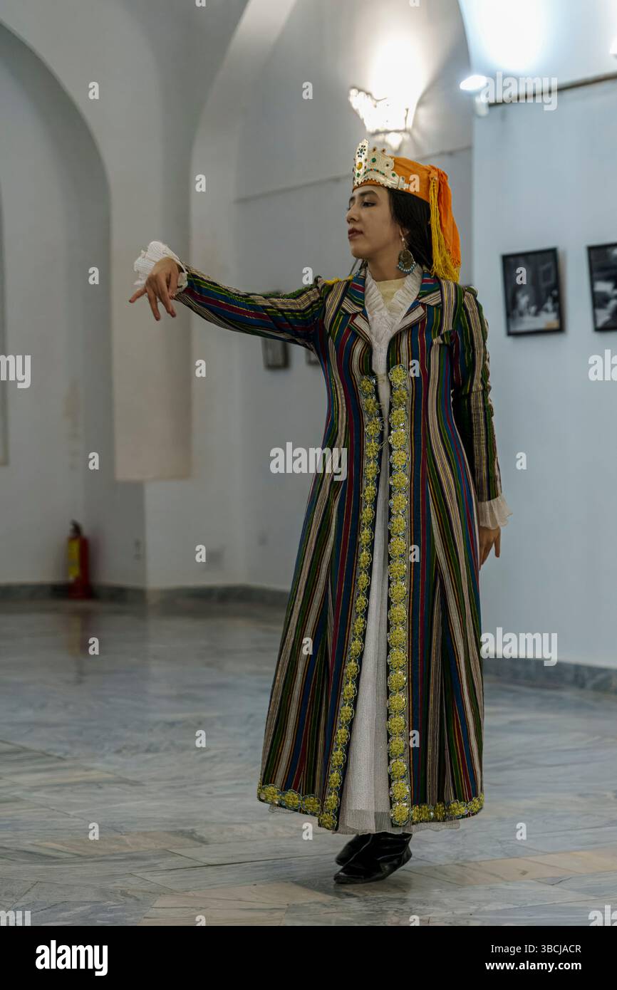 A traditional Uzbek dance performer in colorful costume demonstrates ...