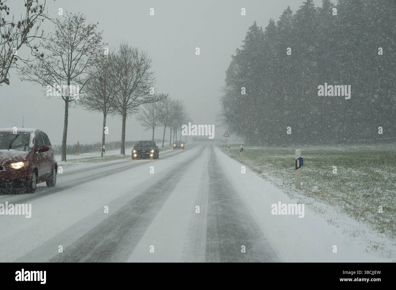 snow storm on a country road and dangerous road conditions in winter in ...