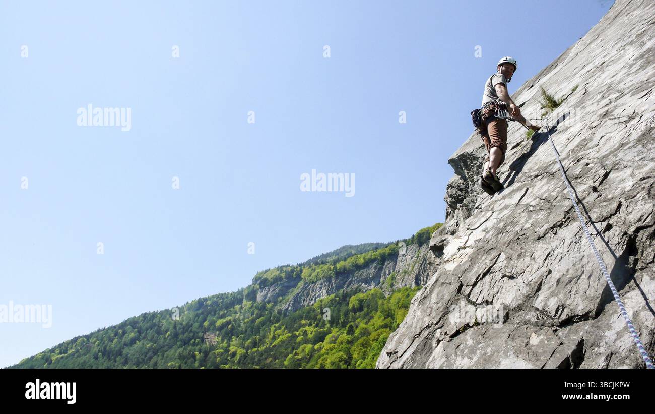 mountain guide rock climber on a slab limestone climbing route in the ...