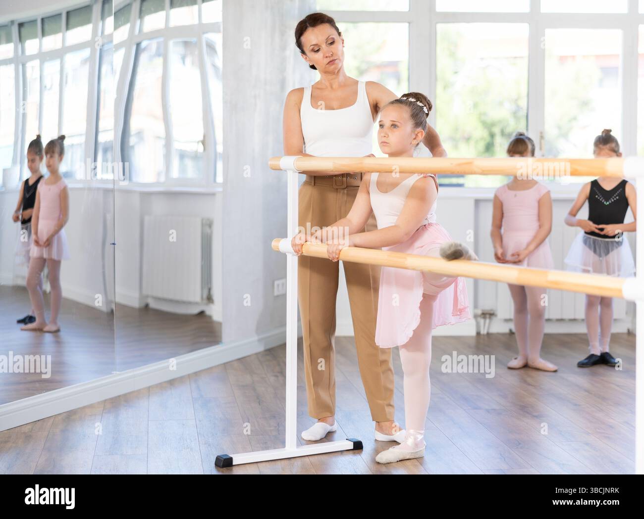 Ballet pose grand batman - little girls at a choreography lesson are ...