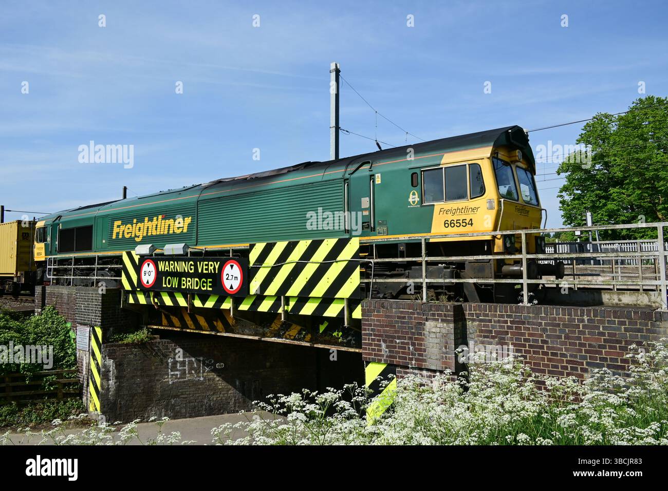 Freightliner Class 66 heads over the infamous low road bridge at Ely ...