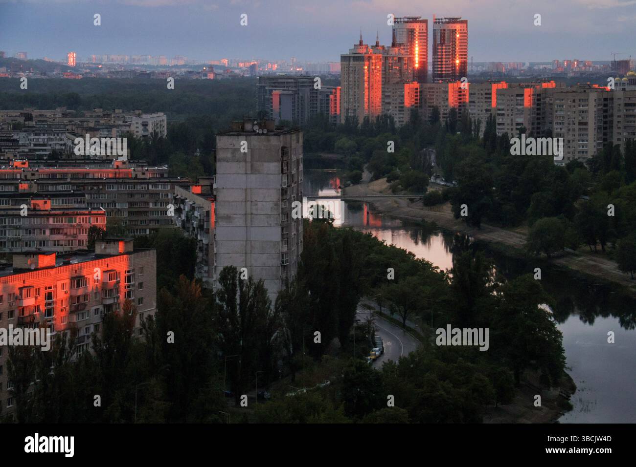The rising sun casts red light on high-rise residential buildings at ...