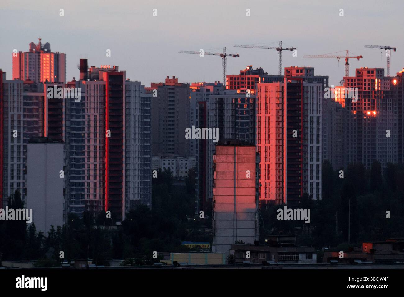 The rising sun casts red light on high-rise residential buildings, Kyiv ...