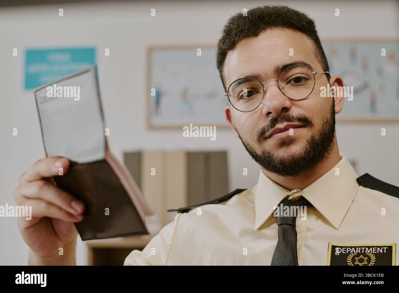 Portrait of uniformed security guard holding identification card ...