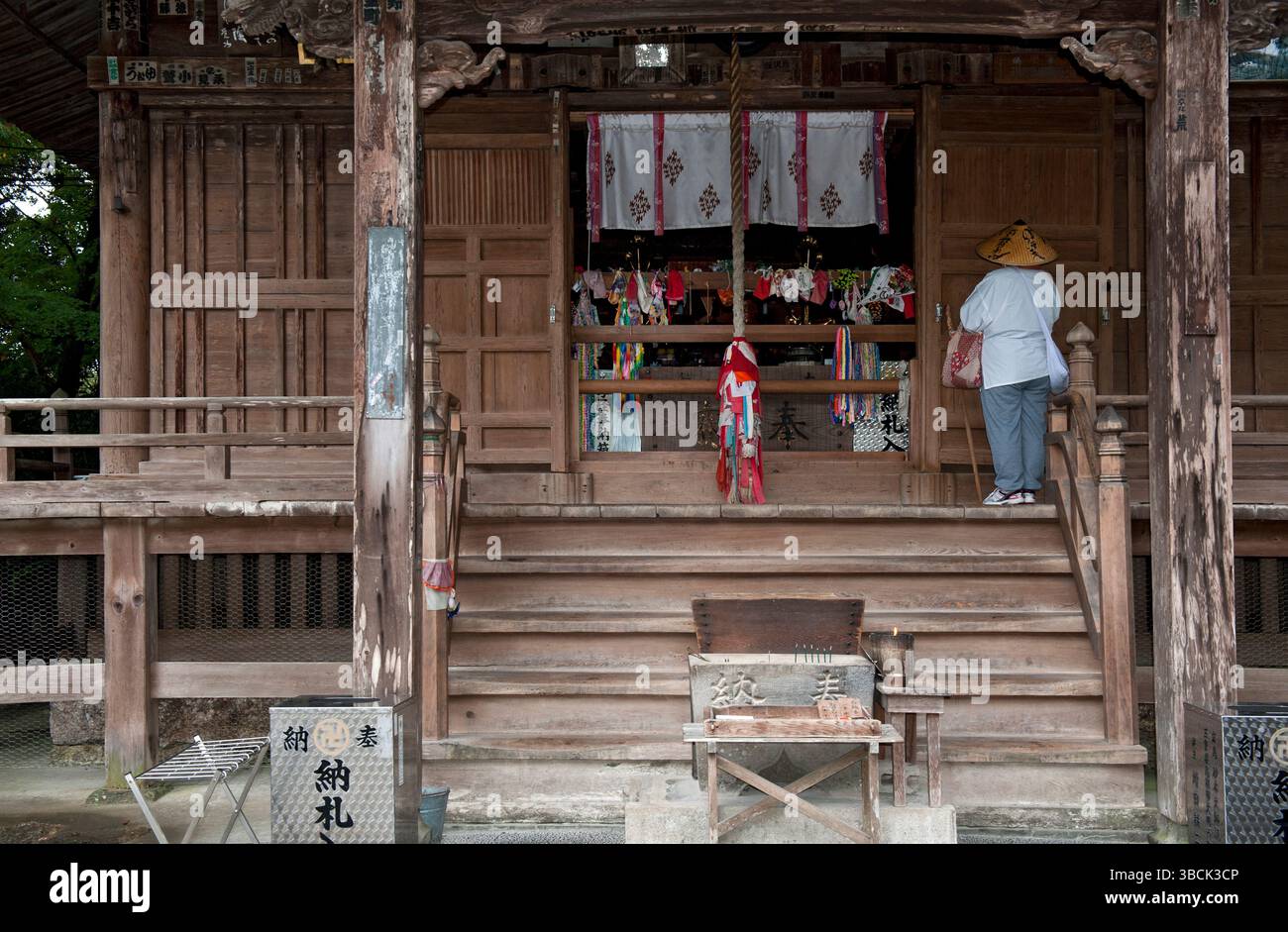 Pilgrim makes a stop at the main hall of Chikurinji Temple, one of 88 ...