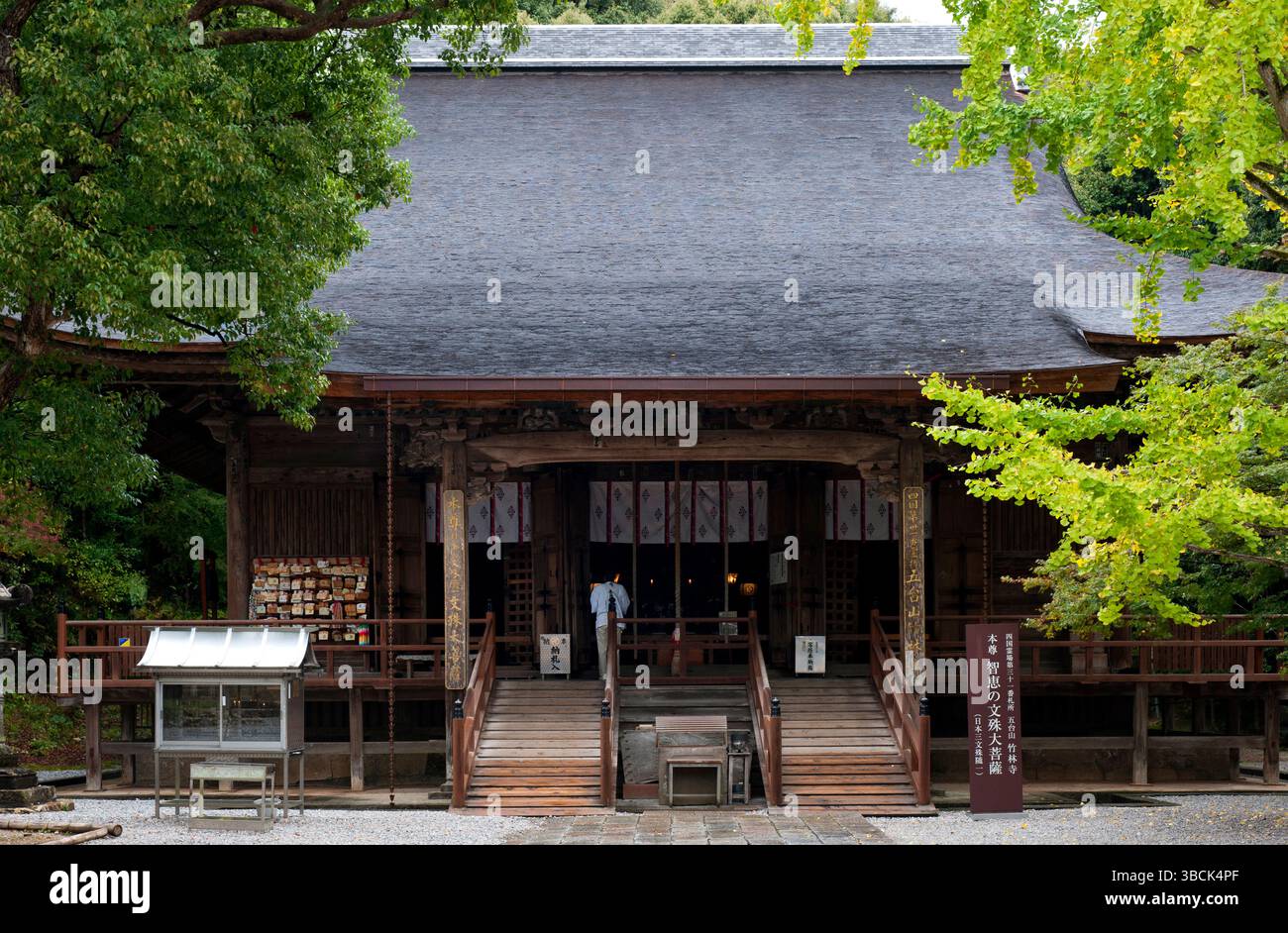Pilgrim makes a stop at the main hall of Chikurinji Temple, one of 88 ...