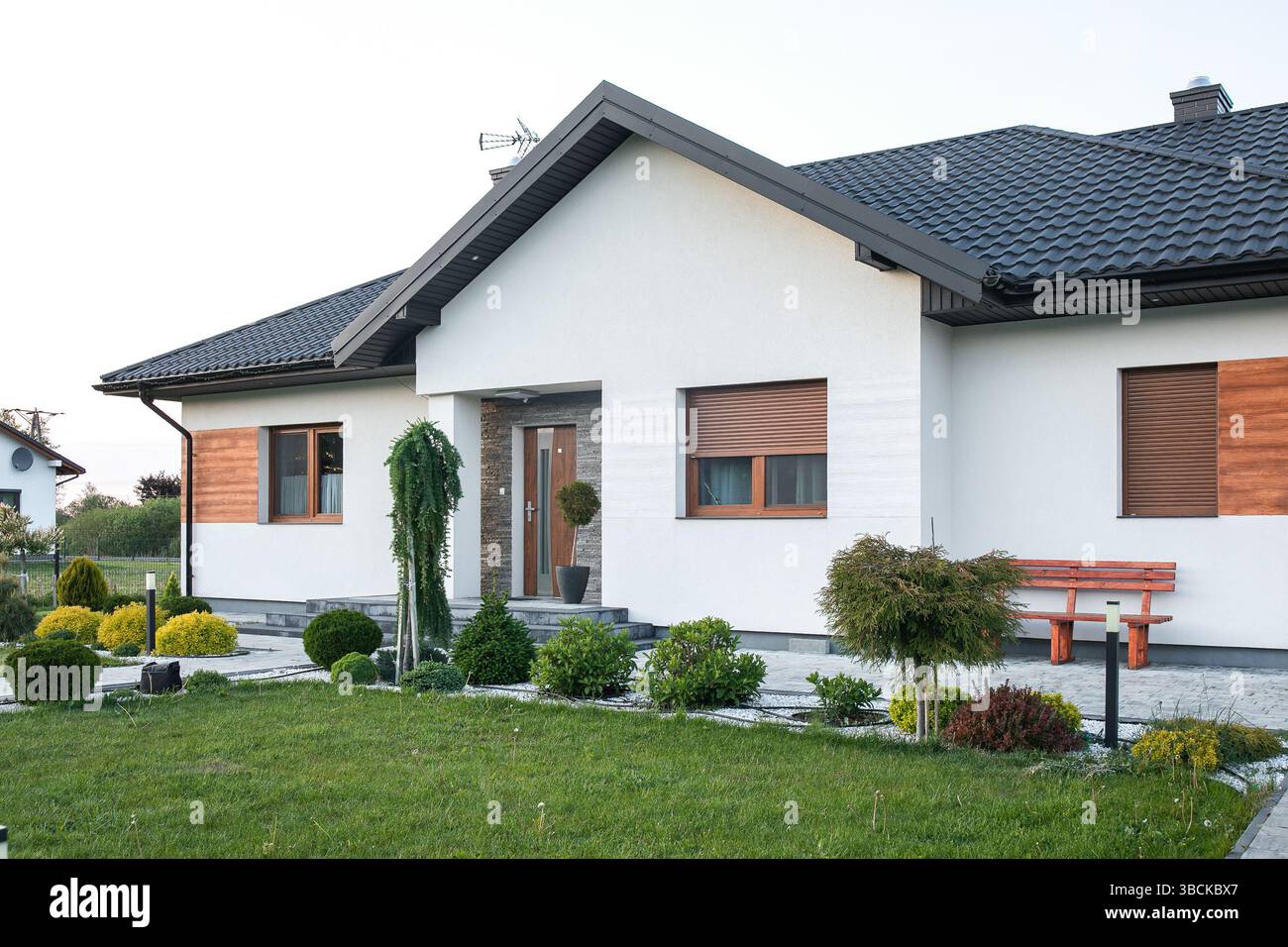 A front door detail with a stone accent wall, a brown door, covered ...