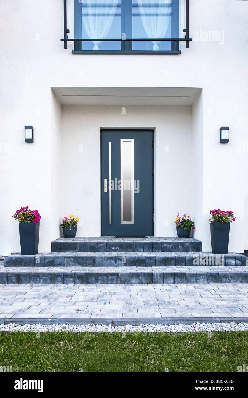 A front door detail with a stone accent wall, a brown door, covered ...