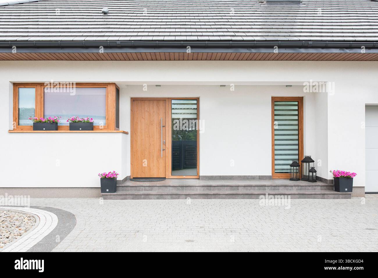 A front door detail with a stone accent wall, a brown door, covered ...
