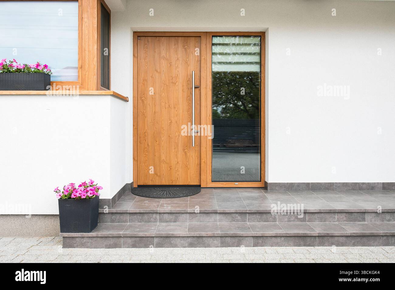 A front door detail with a stone accent wall, a brown door, covered ...