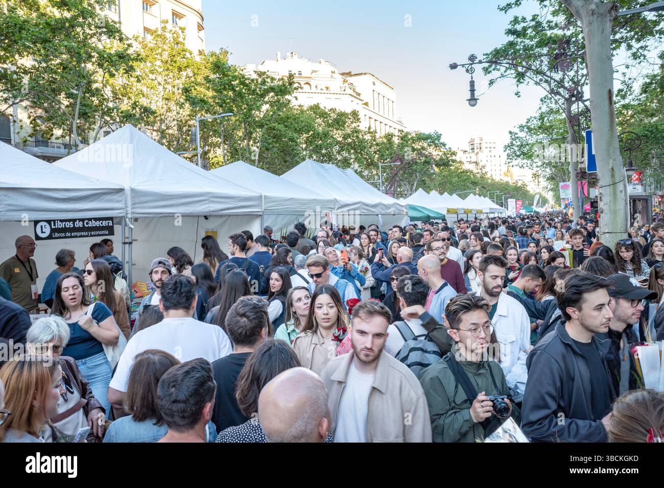 Bustling crowd at Barcelona Sant Jordi festival with white book vendor ...