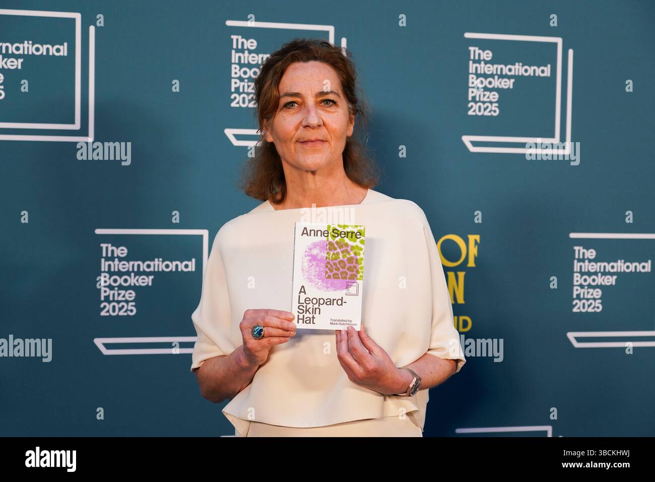 Anne Serre, author of 'A Leopard-Skin Hat', holds her book as she poses ...