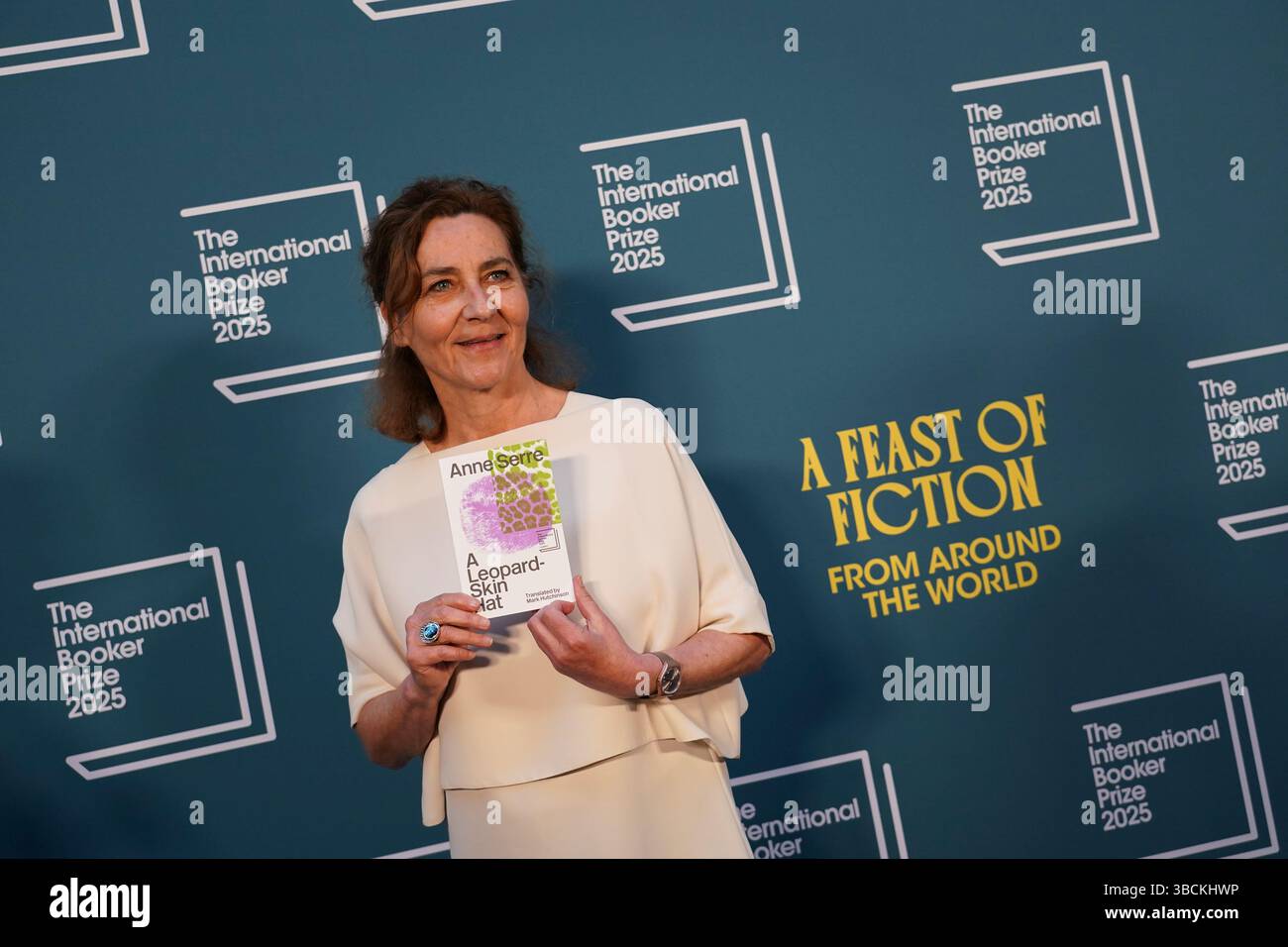 Anne Serre, author of 'Leopard-Skin Hat', holds her book as she poses ...