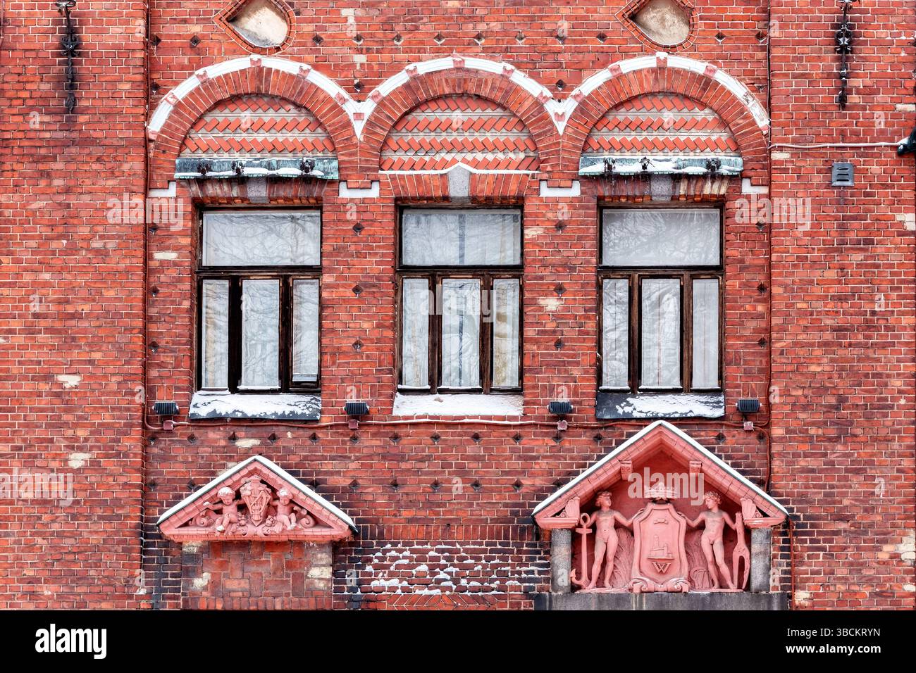 Three rectangular windows with brown frames and arched cornice against ...