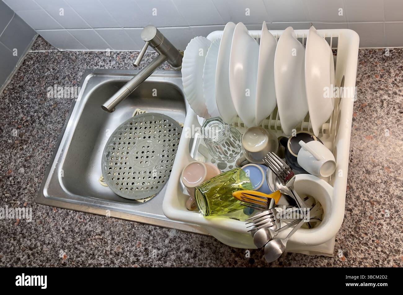 Clean dishes drying in dish rack next to sink in a modern kitchen ...