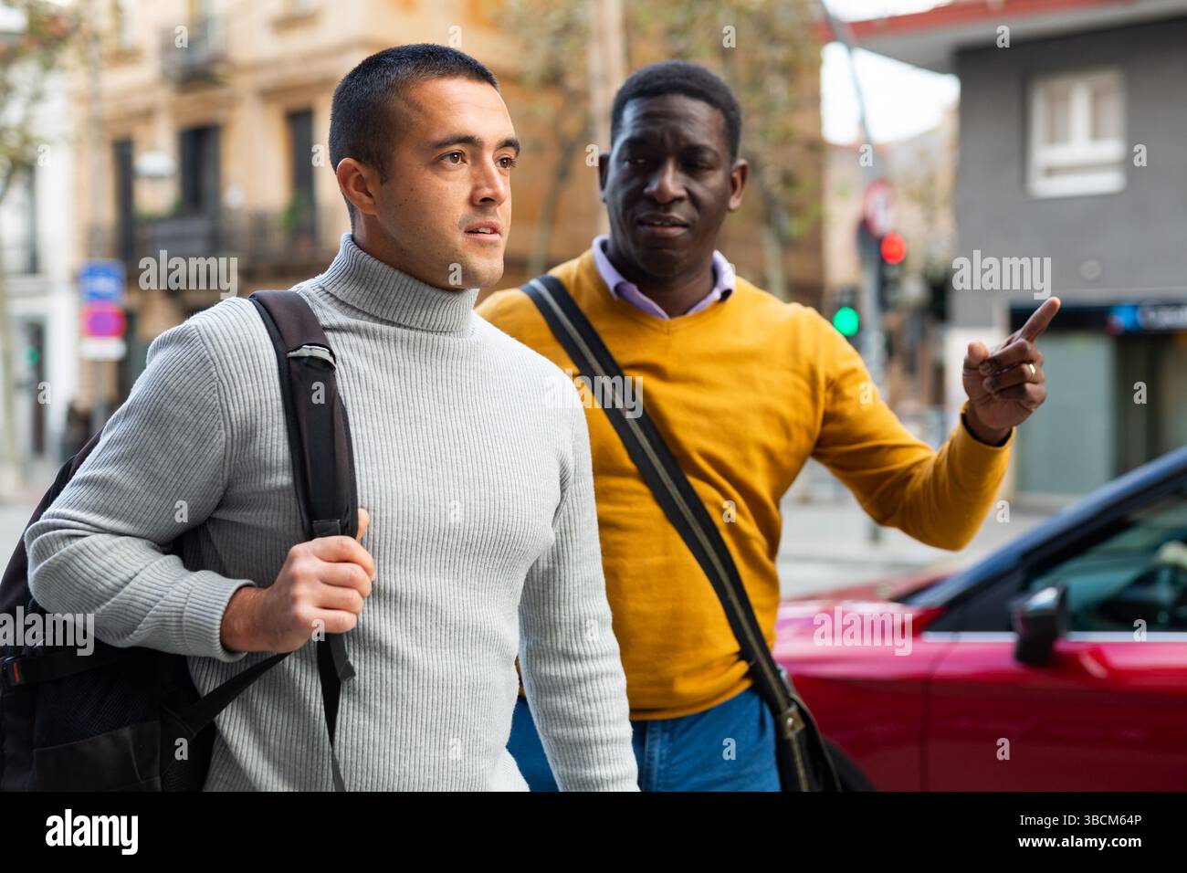 Two men tourists point finger sightseeing at street Stock Photo - Alamy