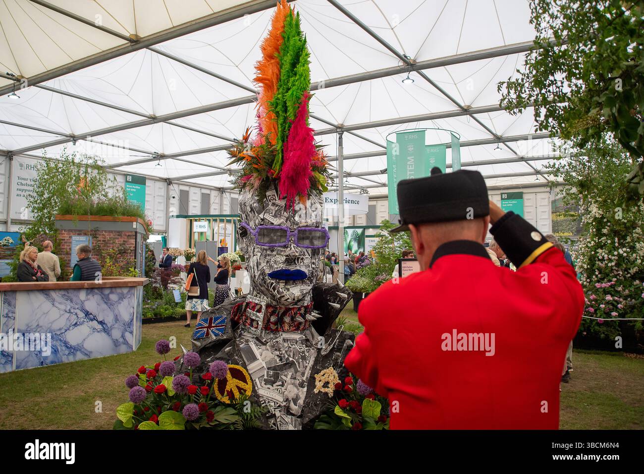 Chelsea, London, UK. 19th May, 2025. A Chelsea Pensioner takes a photo ...