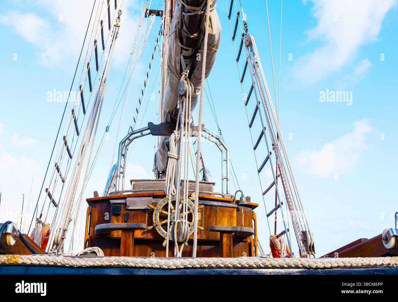 Old wooden sailing ship, closeup. Wooden steering wheel, ropes, rope ...