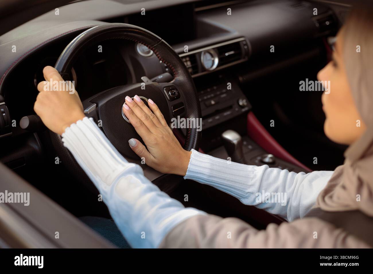 Serious muslim woman driving her car and honking Stock Photo - Alamy