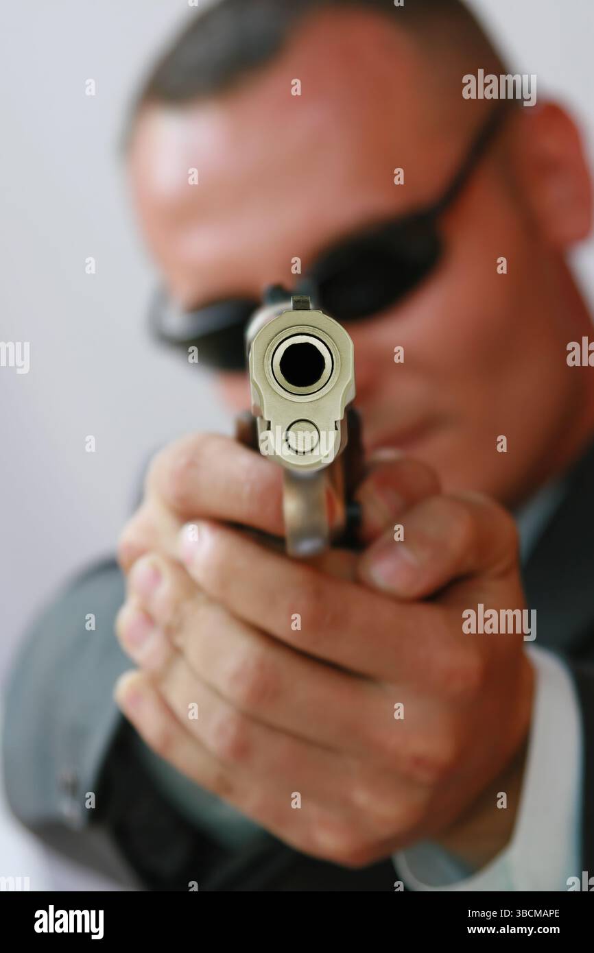 private security guard aiming a pistol, front view down the gun barrel ...