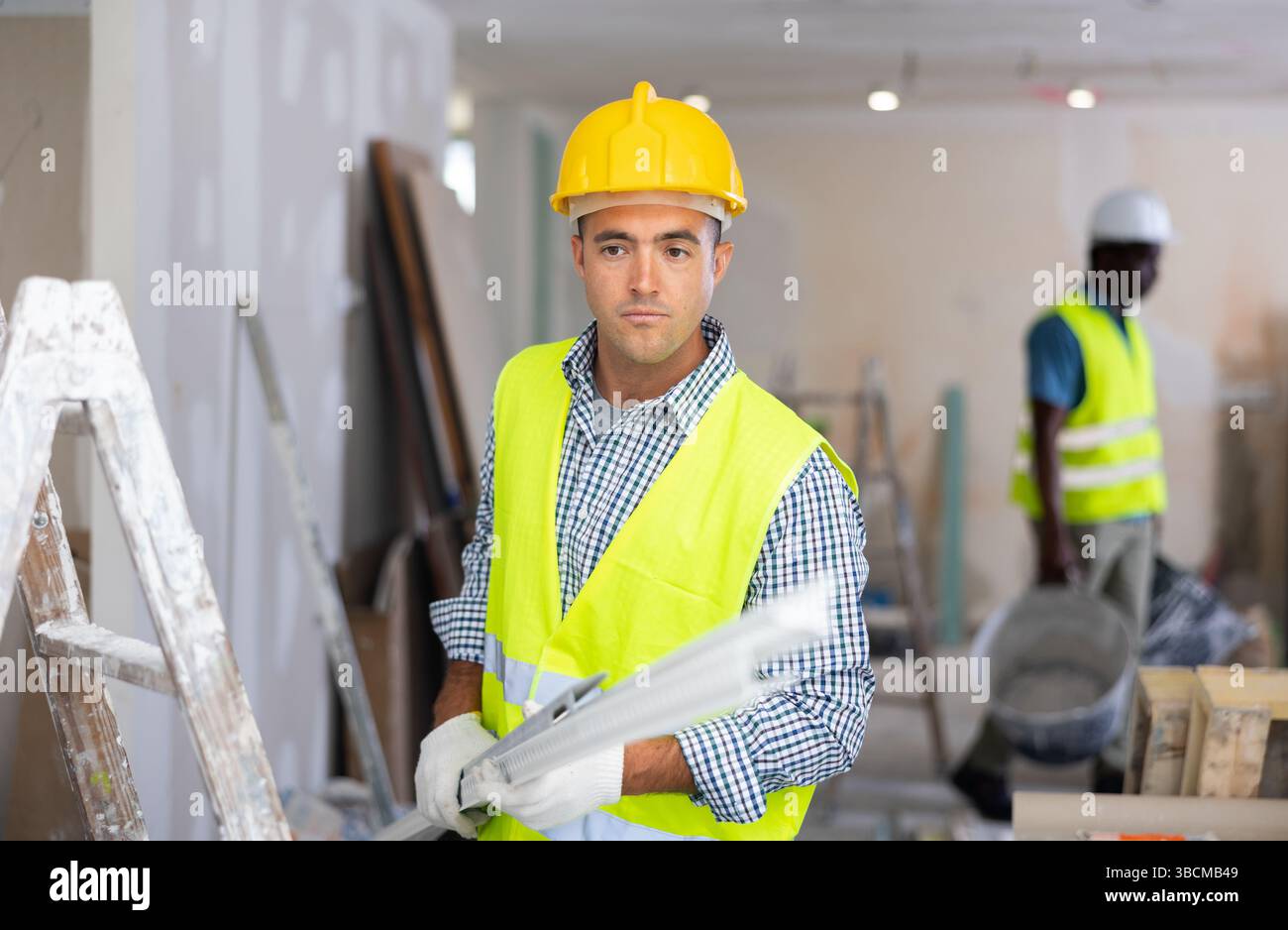 Builder carrying construction detail while working in apartment Stock ...