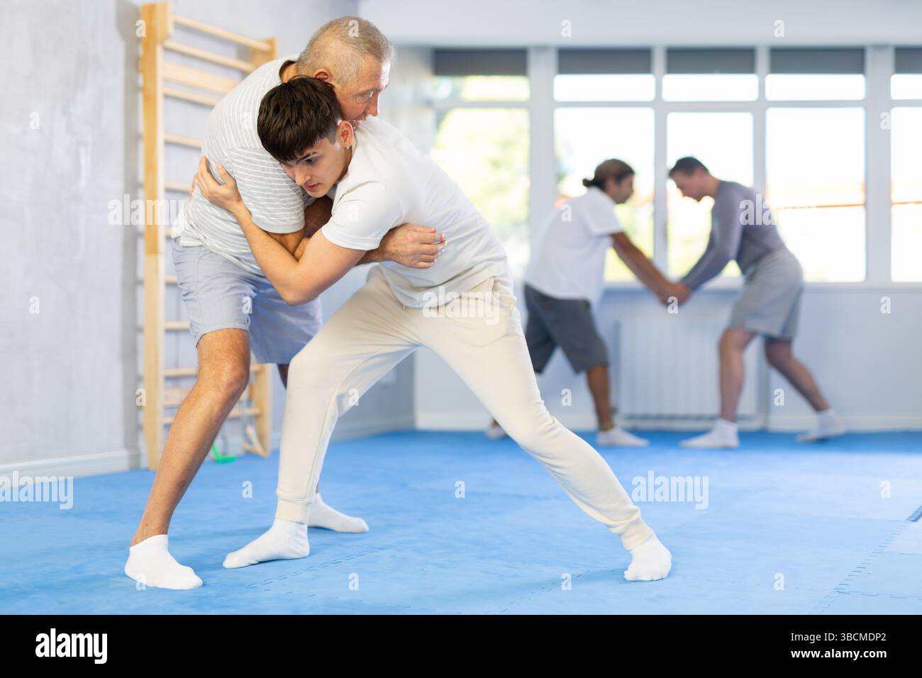 Guy and senior man athletes in pair conduct training battle in oriental ...