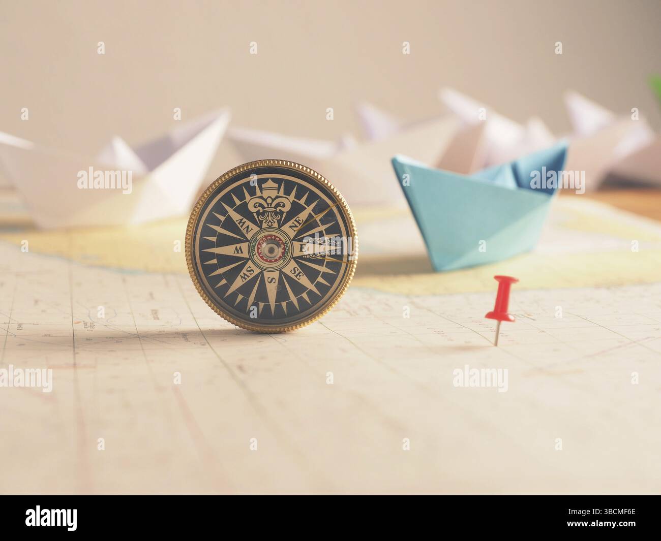 Close up of a compass and location marking with a red pin on sea map ...