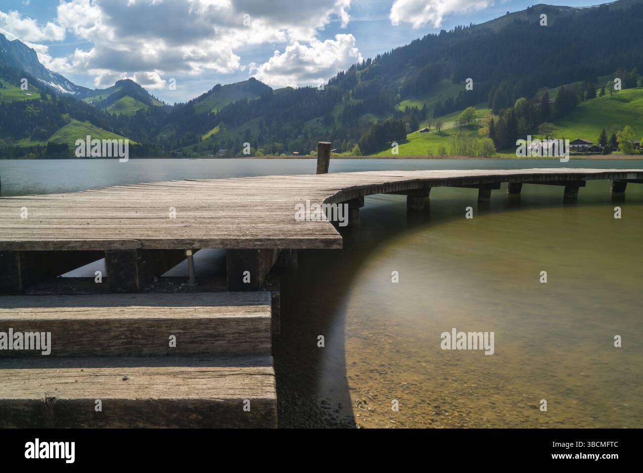 Horizontal view of a long wooden boardwalk on a calm and placid ...
