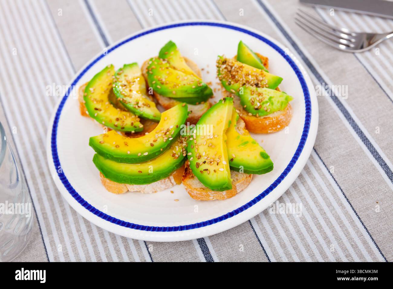 Avocado and sesame toast served on platter Stock Photo - Alamy