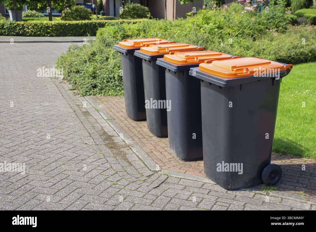 Row of european grey waste bins along street Stock Photo - Alamy
