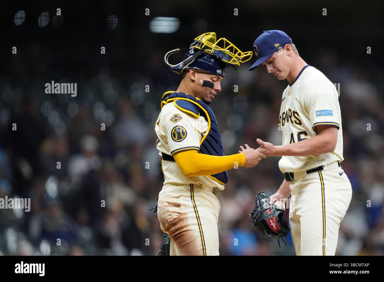 Milwaukee Brewers' William Contreras, left, looks at the hand of Quinn ...