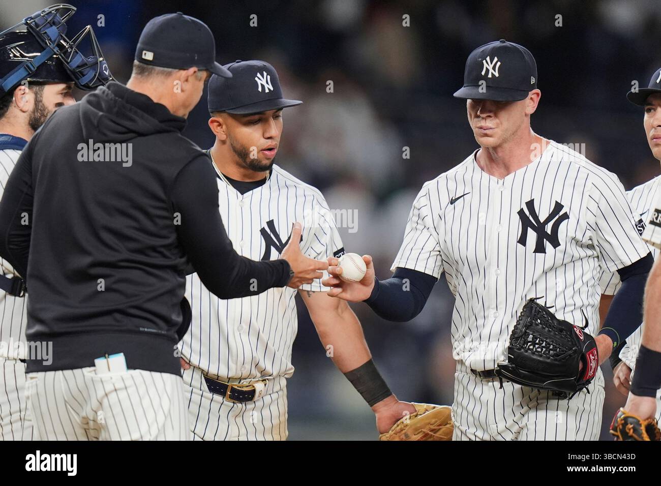 New York Yankees pitcher Ian Hamilton, right, hands the ball to manager ...