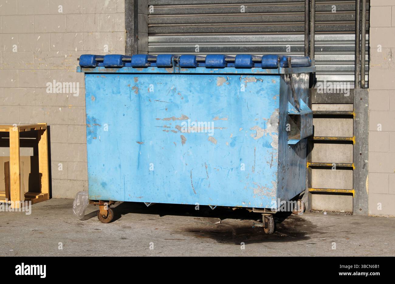 Large blue dumpster in a concrete industrial area Stock Photo - Alamy
