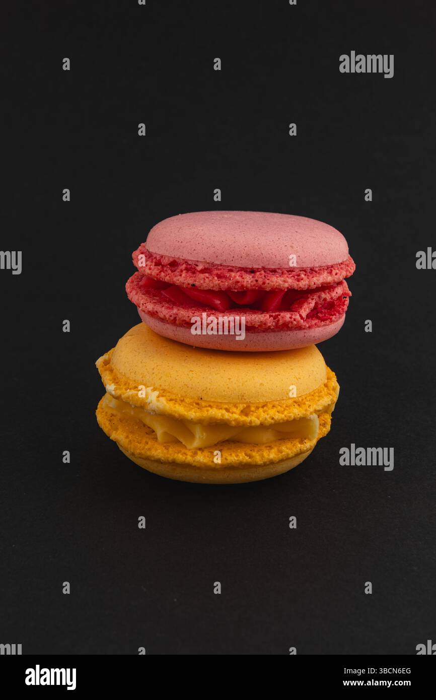 Two vibrant macarons are stacked together, featuring a pink macaron ...