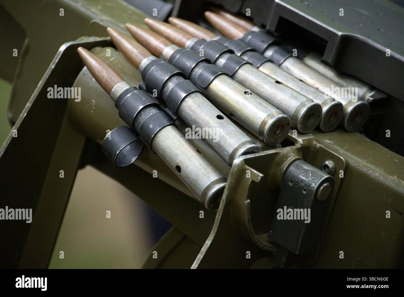 An up-close view displays machine gun rounds neatly lined up, ready for ...