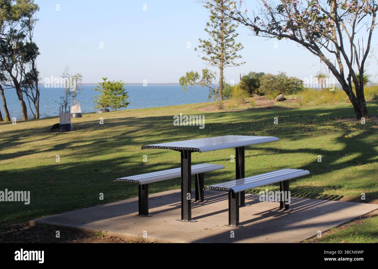 Picnic table, trees and the ocean at Friend Park in Gladstone ...