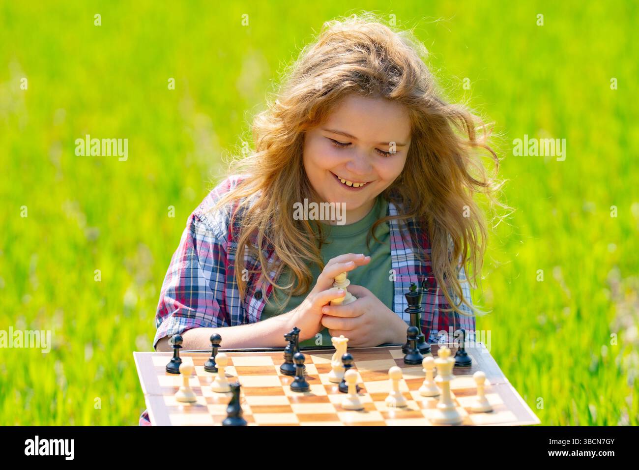 Kid plays chess. A clever cute child thinks and playing chess. Kid ...