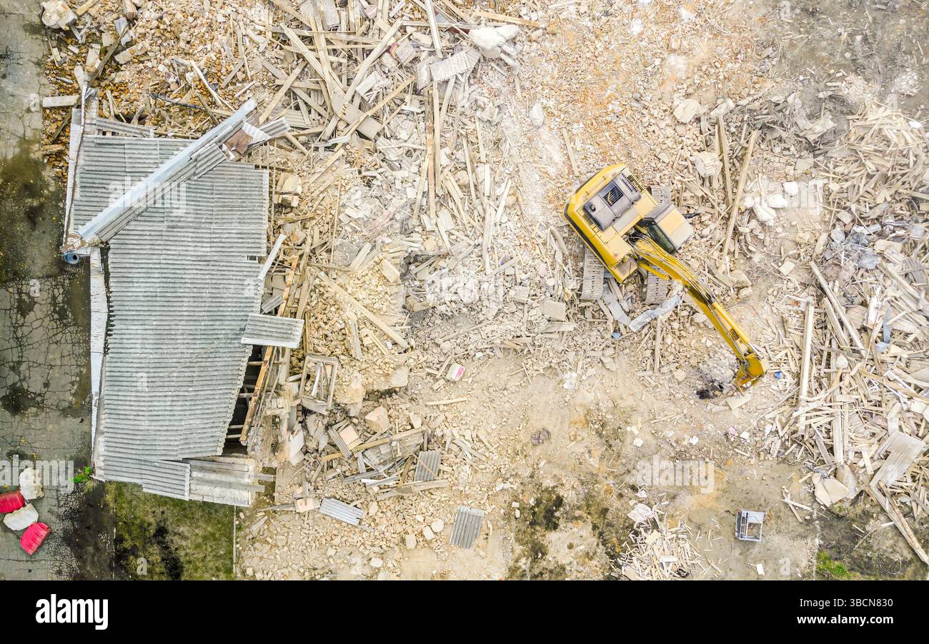 backhoe clearing out pile of debris of destroyed building after ...