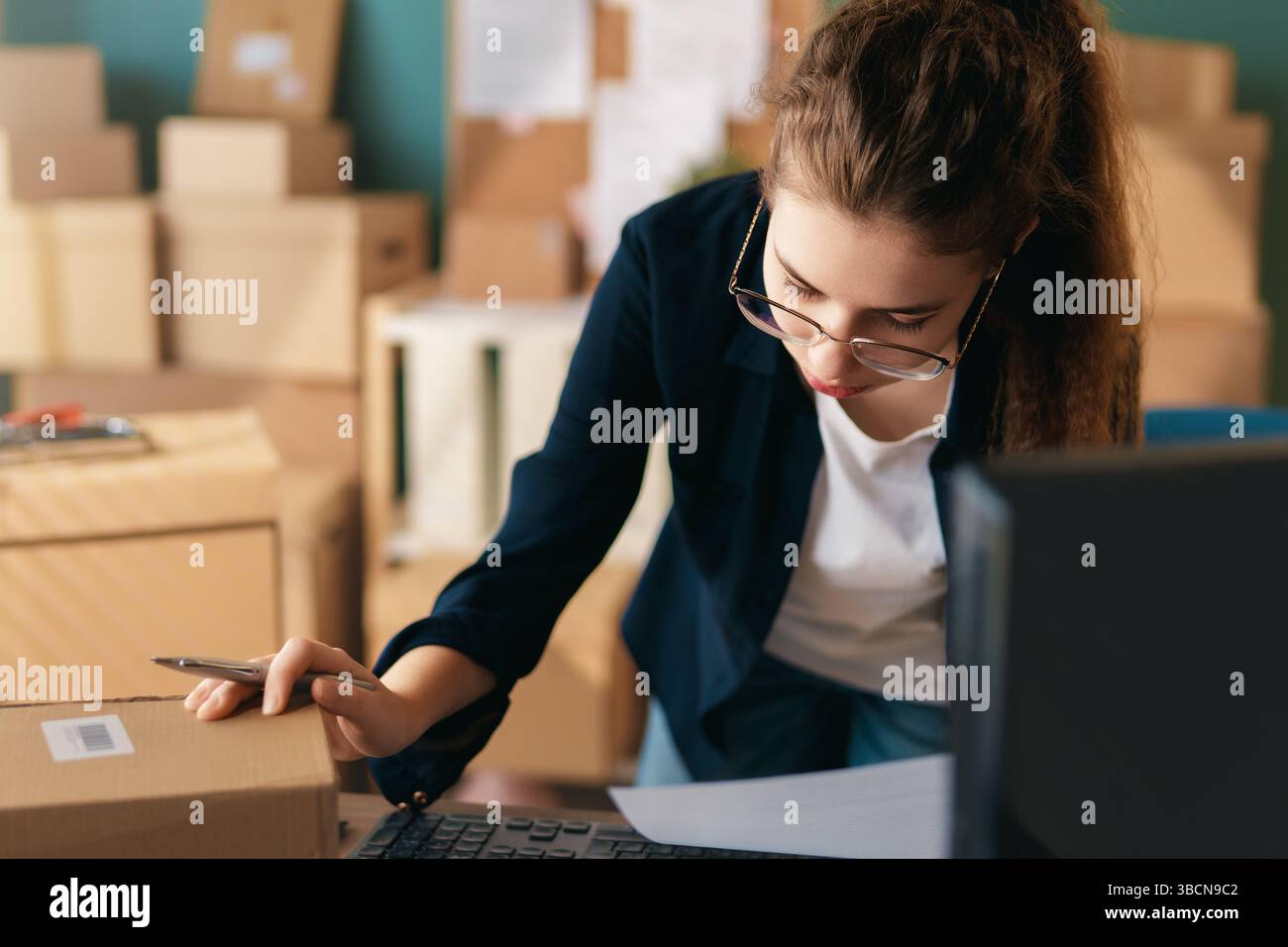 Female inventory manager checking stock. Woman working in a warehouse ...